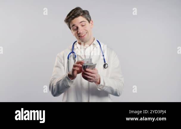Rich doctor man counting money. Handsome medical health care worker in white coat with USD ...
