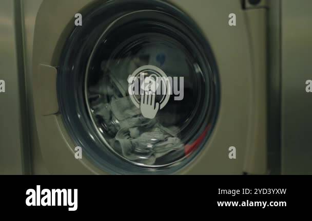 Close-up of a front-loading washing machine with clothes spinning ...
