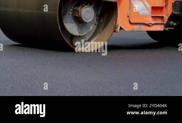 Asphalt laying. Road building asphalt paver is laying a new layer of ...