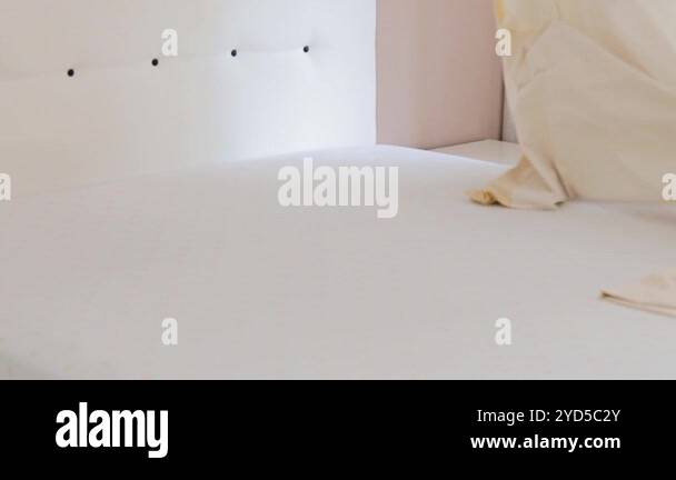 A person carefully performs a household task of making the bed by ...