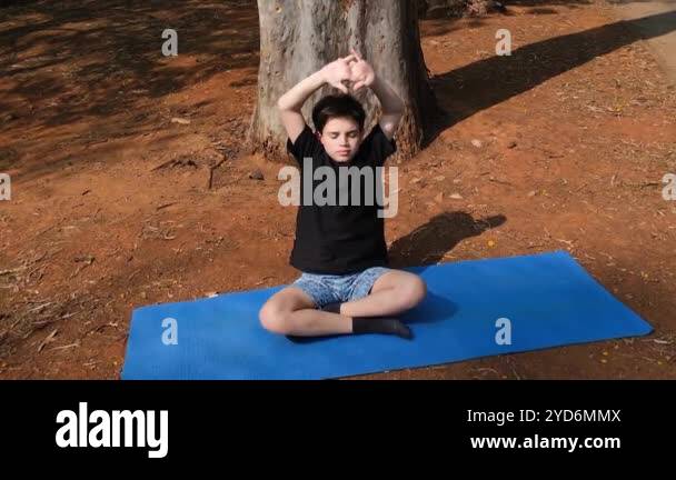 11 year old Brazilian boy sitting on the Met and stretching in a yoga ...