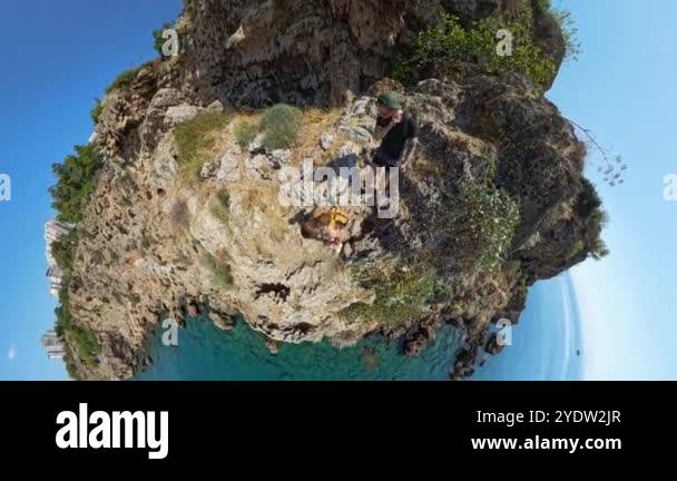 360 degree camera A Man and Woman hike along a narrow cliff edge above ...