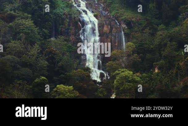Scenic footage of Kuda Ravana Ella waterfall flowing down rocky cliffs ...
