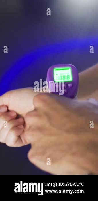 Close-up check temperature on hand. Media. People go to shopping malls ...