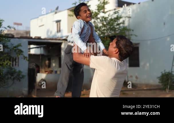 Young father lifting up his laughing little boy overhead in the air ...