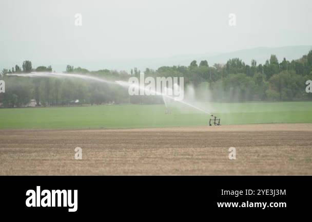 A powerful tractor runs an irrigation system, efficiently supplying ...