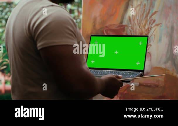 African american artist holding device with green screen mockup in art ...