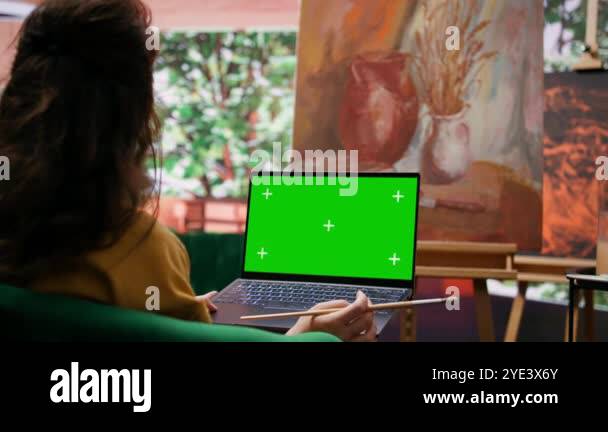 Painter admiring her creative masterpiece in art studio next to green ...