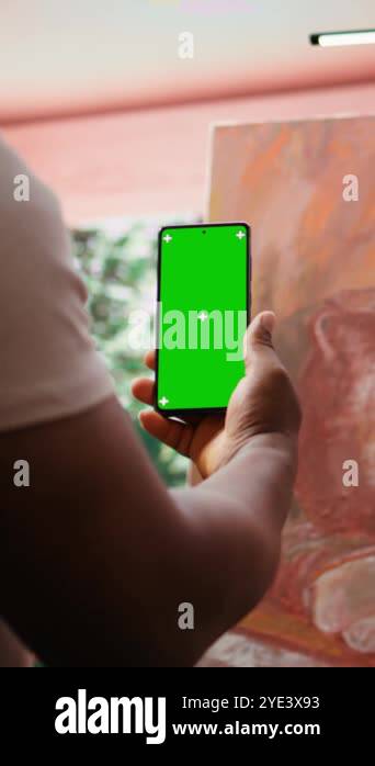 Vertical Video Young artist looking at isolated chroma key display in ...