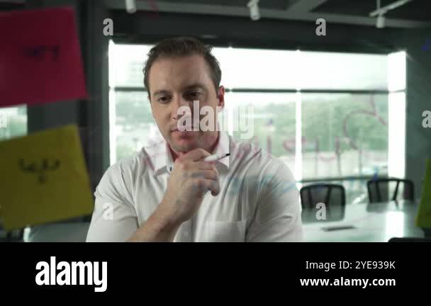 Smart businessman thinking about start up project in front of glass ...