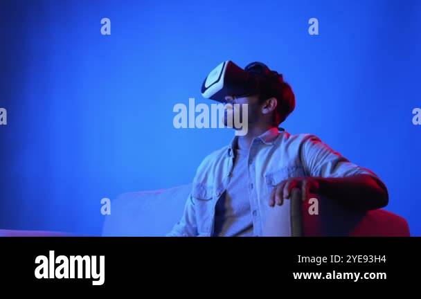 Excited caucasian man sitting at sofa with fear while watching horror ...