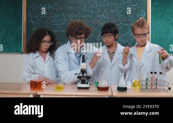 Skilled child hold tube while doing experiment while smart teacher ...