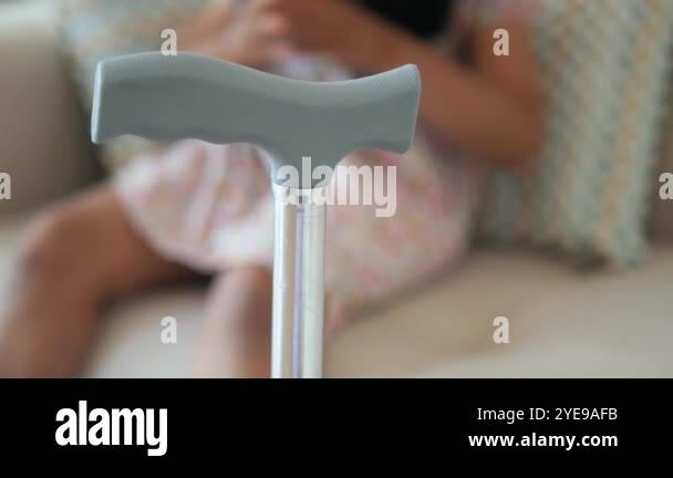 A child grips the handlebar of a walker, focusing on stability and support. The image conveys ...