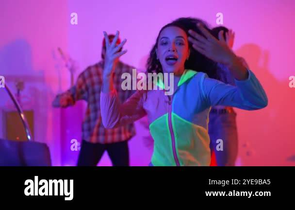 Attractive break dancer looking at camera while friend dancing behind ...