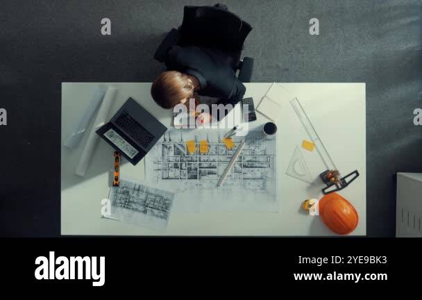 Top down view civil engineer writing sticky note and looking at laptop ...