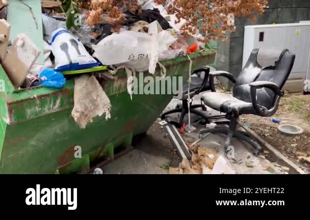 Things thrown in the trash in a big city. An overflowing garbage ...