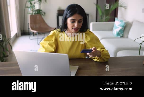 Focused young Indian bank client woman making money transaction ...