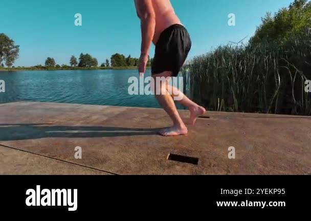 Clumsy heavyset man jumping headfirst into cold refreshing water. Bald ...