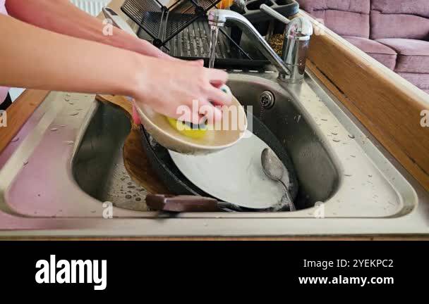 Washing Dishes in Modern Kitchen Sink With Sponge and Soapy Water in ...