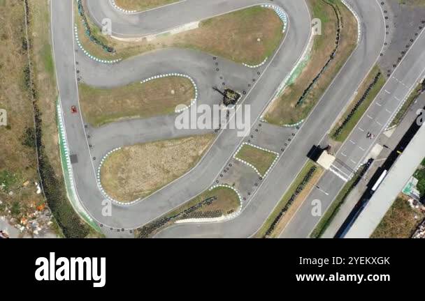 Overhead drone view of go-karts moving on winding race tracks from ...