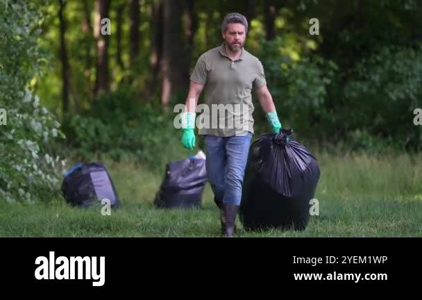 Volunteer man picking plastic trash for cleaning the nature. Clean up ...