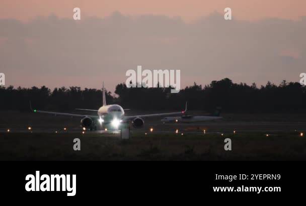 A passenger plane takes off in the evening from the runway of the ...