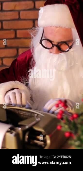 In a cozy setting, Santa Claus types on an old typewriter in his red ...