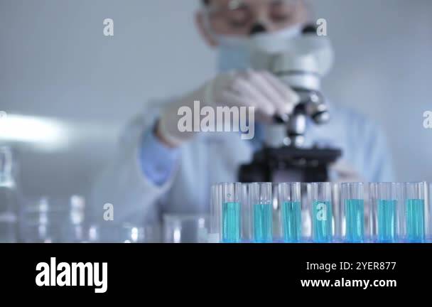 Laboratory tubes, filled with a blue liquid, are in focus, closeup view ...
