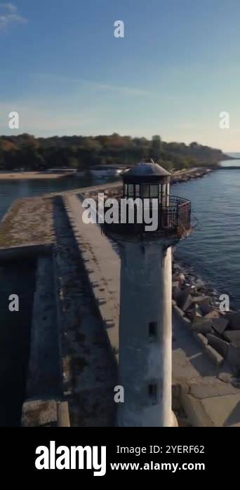 Drone footage of a coastal lighthouse on rocky breakwater, scenic ...