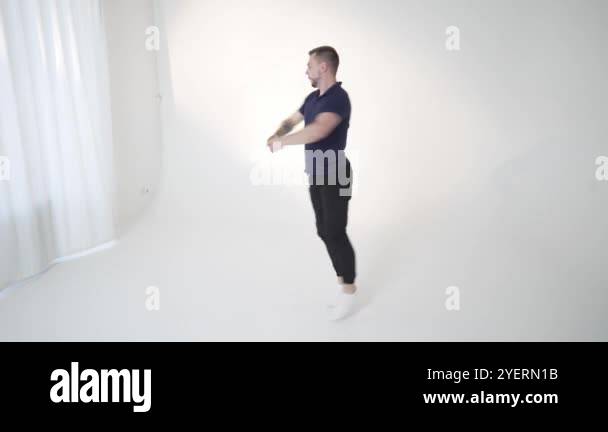 A fit and dedicated man is practicing various dance movements in a ...