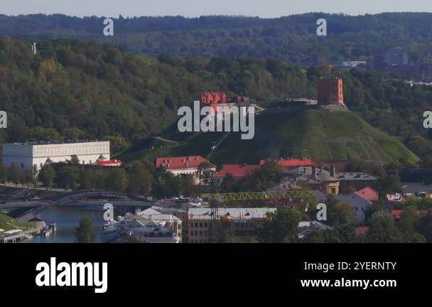 Gediminas Tower stands with the Lithuanian flag, surrounded by lush ...