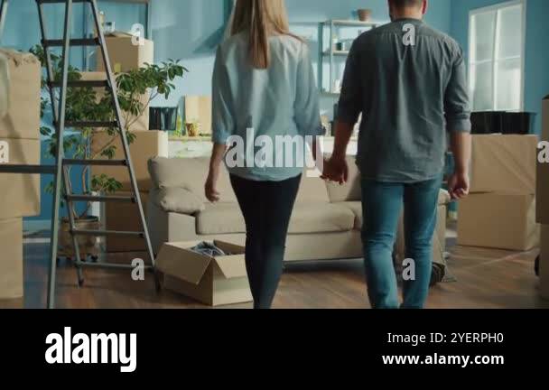 A Couple Walks Hand-in-Hand in Their New Apartment, Surrounded by ...