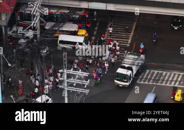 Lively city scene at a bustling Manila intersection, where people, cars ...