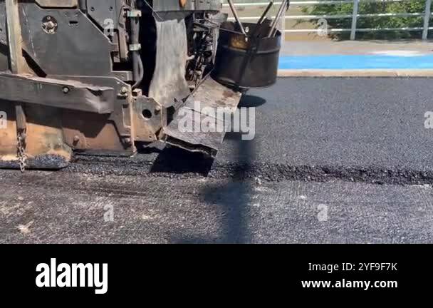asphalt paver machine laying fresh asphalt on a road. The image ...