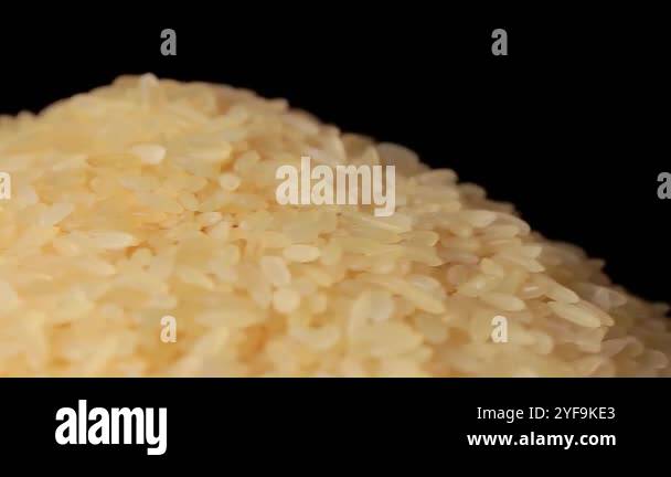 Dry Uncooked Parboiled Rice Heap Rotating against Black Background. A ...