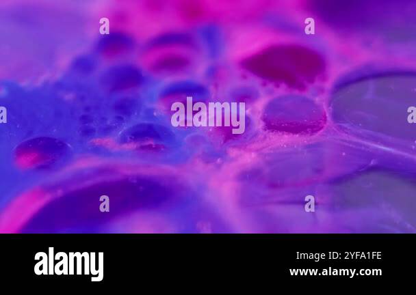 Sparkling serum. Wet foam. Defocused neon pink purple blue color ...