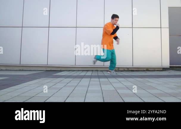 young energetic guy dancer breaksdancing outdoors in the city on the ...