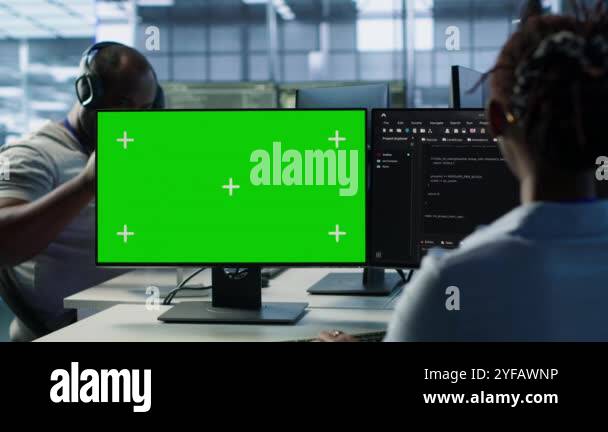 IT specialist in server farm using green screen PC ensuring valuable data remains shielded from ...