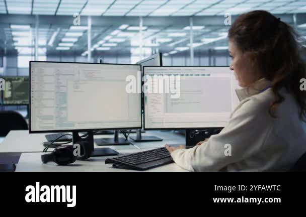 Employee sitting next to african american coworkers in data center doing checkup on electronics ...