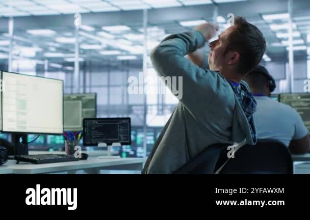 Fatigued admin stretching at work in server room to relieve muscle ...