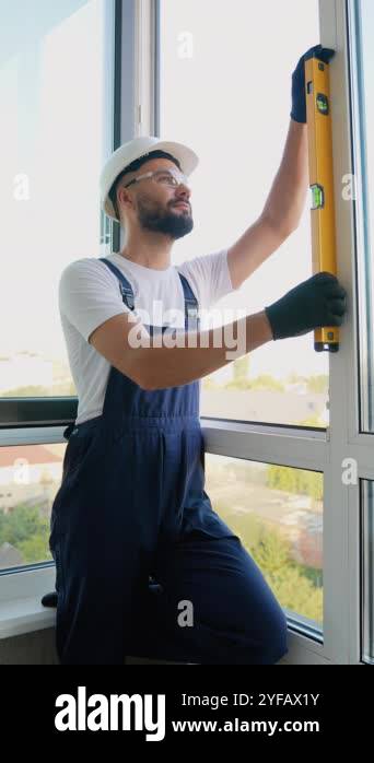 Professional installer carefully uses a spirit level to check the ...