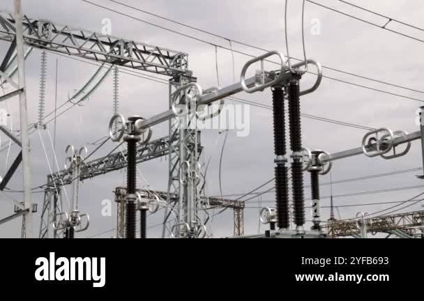 High voltage electrical substation. Power plant with high poles and voltage distribution cables ...