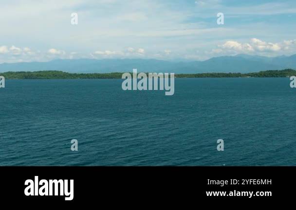 Ocean waves and tropical island. Blue sky and clouds. Samal, Davao ...