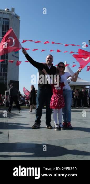 Izmir, Turkey - Oct 29 2024: A family of three poses with Turkish flags ...
