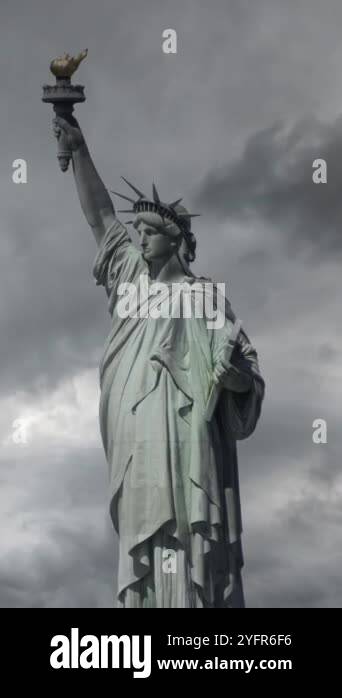 Statue of Liberty standing tall as storm clouds roll in. Vertical video ...