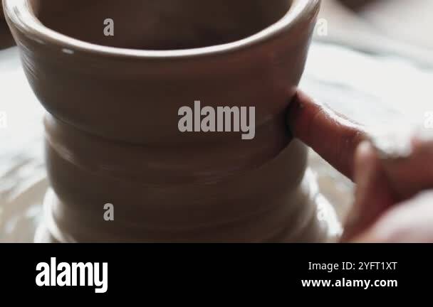 Close up unrecognizable pottery master pushing with finger on side of ...