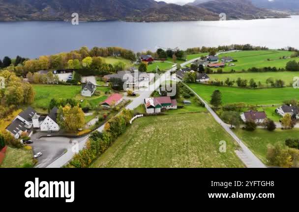 Aerial view of a picturesque coastal village with houses, green fields ...