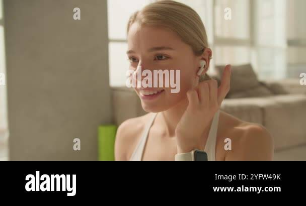A woman with a radiant smile holds wireless earbuds, expressing joy and ...