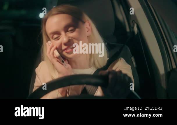 Drunk tipsy smiling laughing Caucasian woman female girl auto driver talk mobile phone call ...
