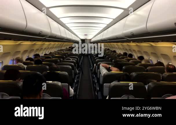 Interior of commercial airplane cabin with passengers seated, ready for ...